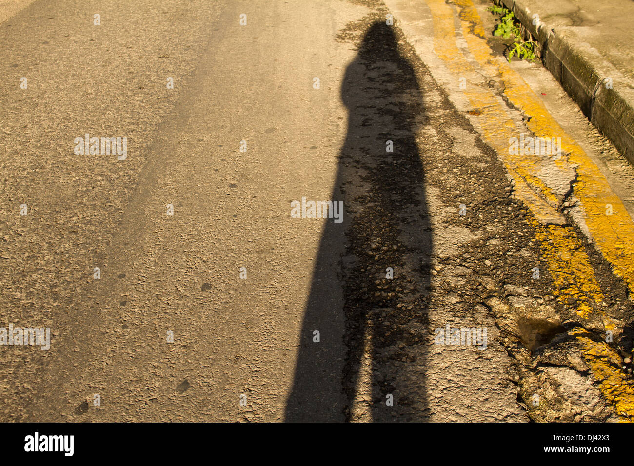 Shadow on a black broken road surface with a yellow line Stock Photo ...