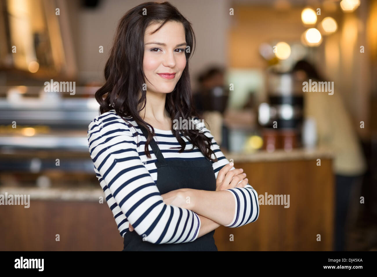 Pretty Waitress Standing Arms Crossed In Cafeteria Stock Photo - Alamy