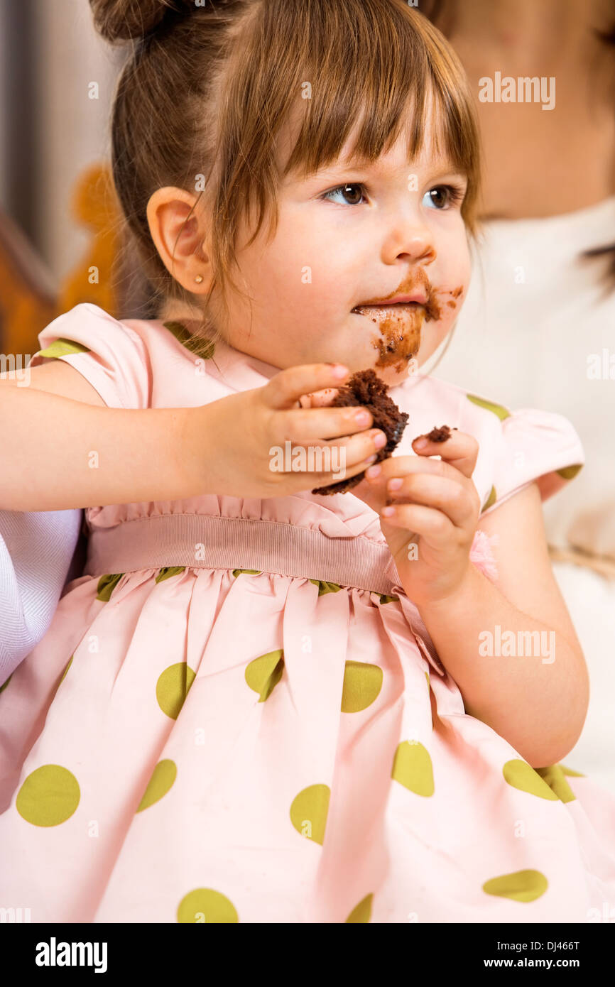 Birthday Girl Eating Cake With Icing On Her Face Stock Photo - Alamy
