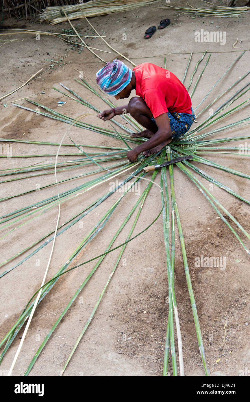 Indian man weaving a traditional goat pen from bamboo in a rural Indian ...