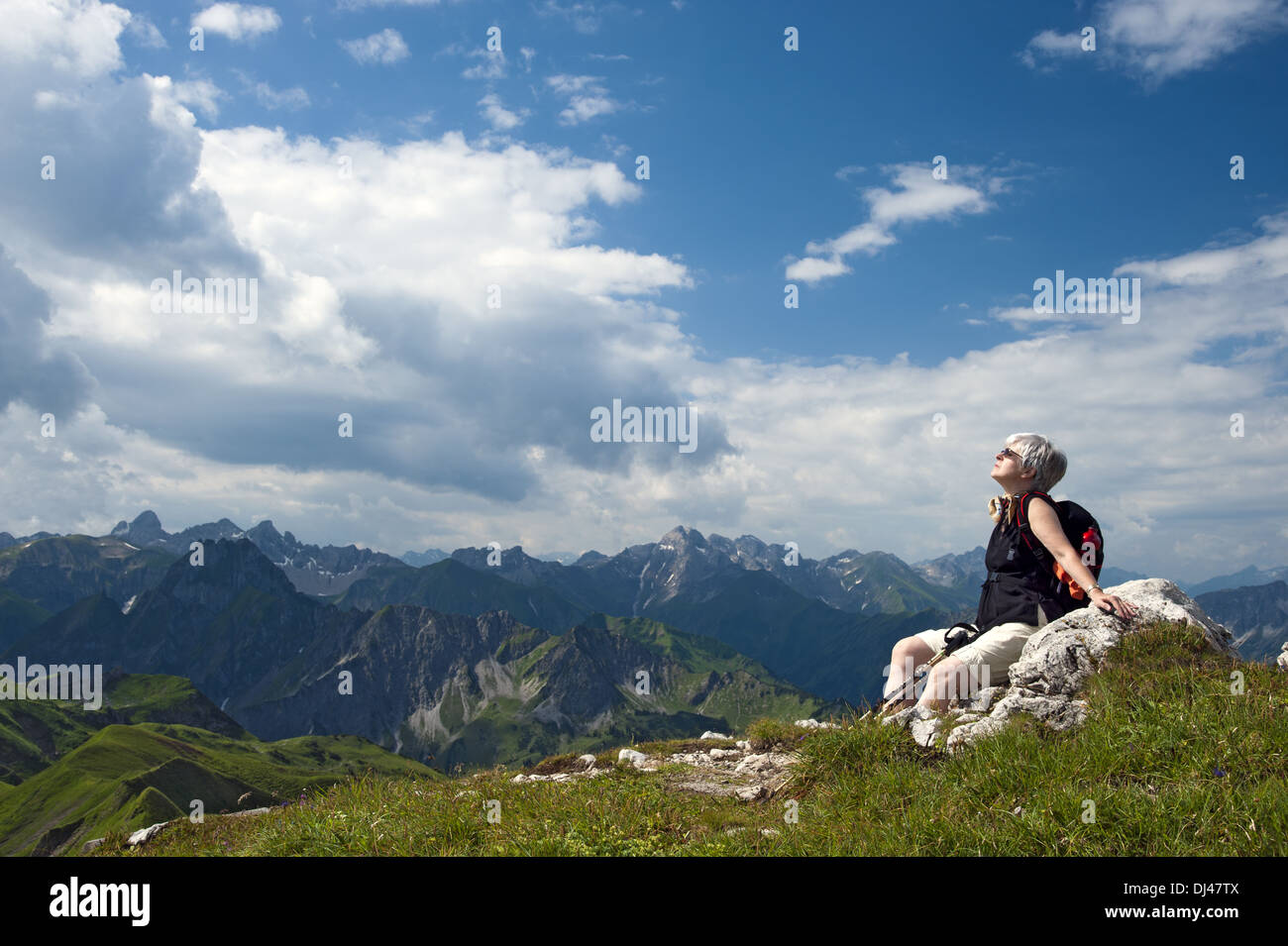 Woman sitting on a rock Stock Photo - Alamy