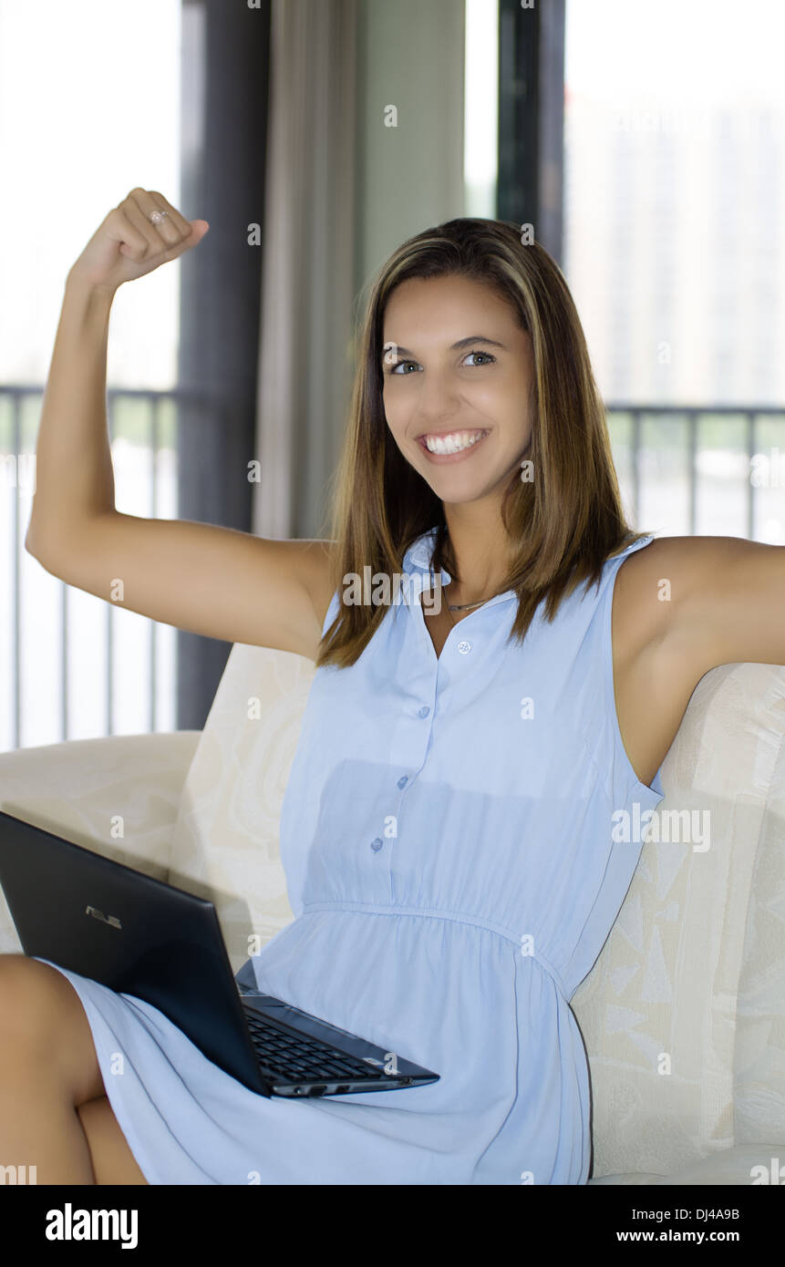 Confident, happy college student with laptop showing that that she is ...