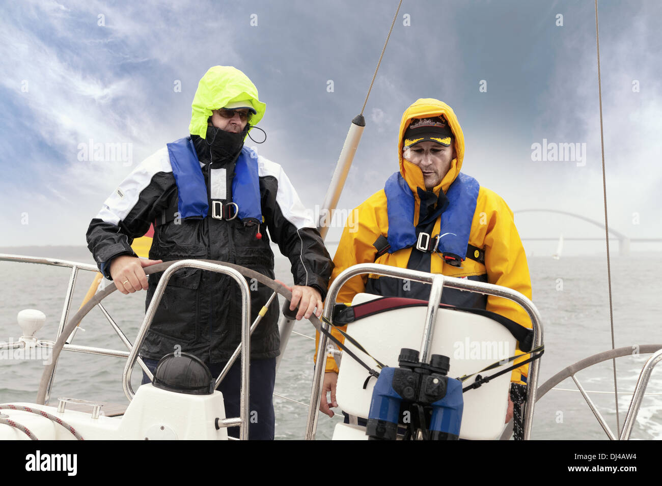 2 men standing at the stern of a yacht Stock Photo - Alamy