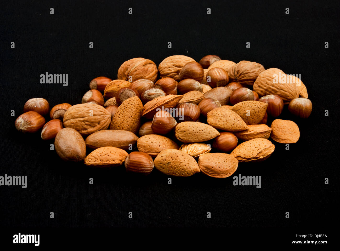 Selection of nuts on a black background Stock Photo - Alamy