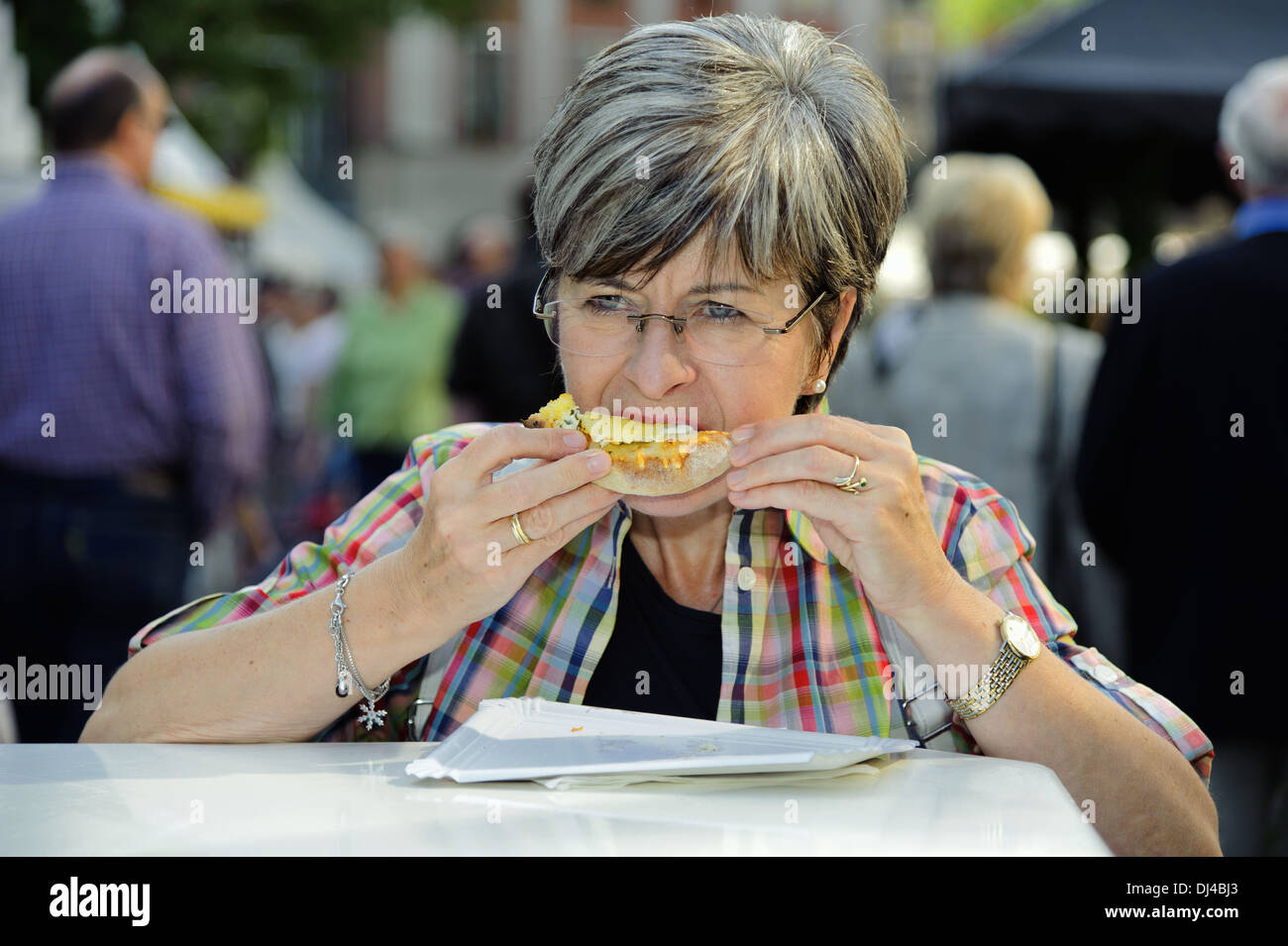 Woman biting into a piece of bread Flame Stock Photo - Alamy