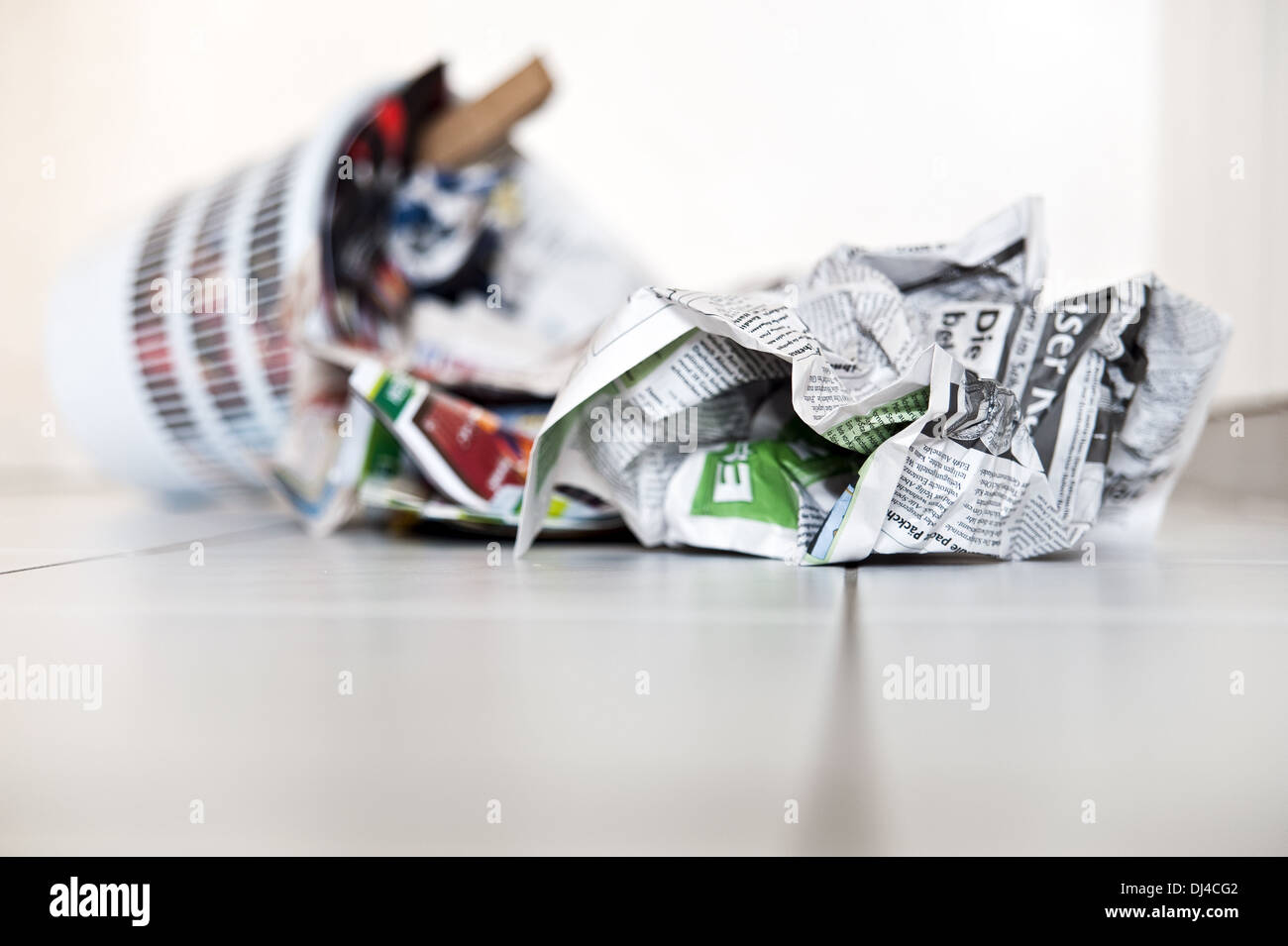 overturned trash with newspapers Stock Photo - Alamy