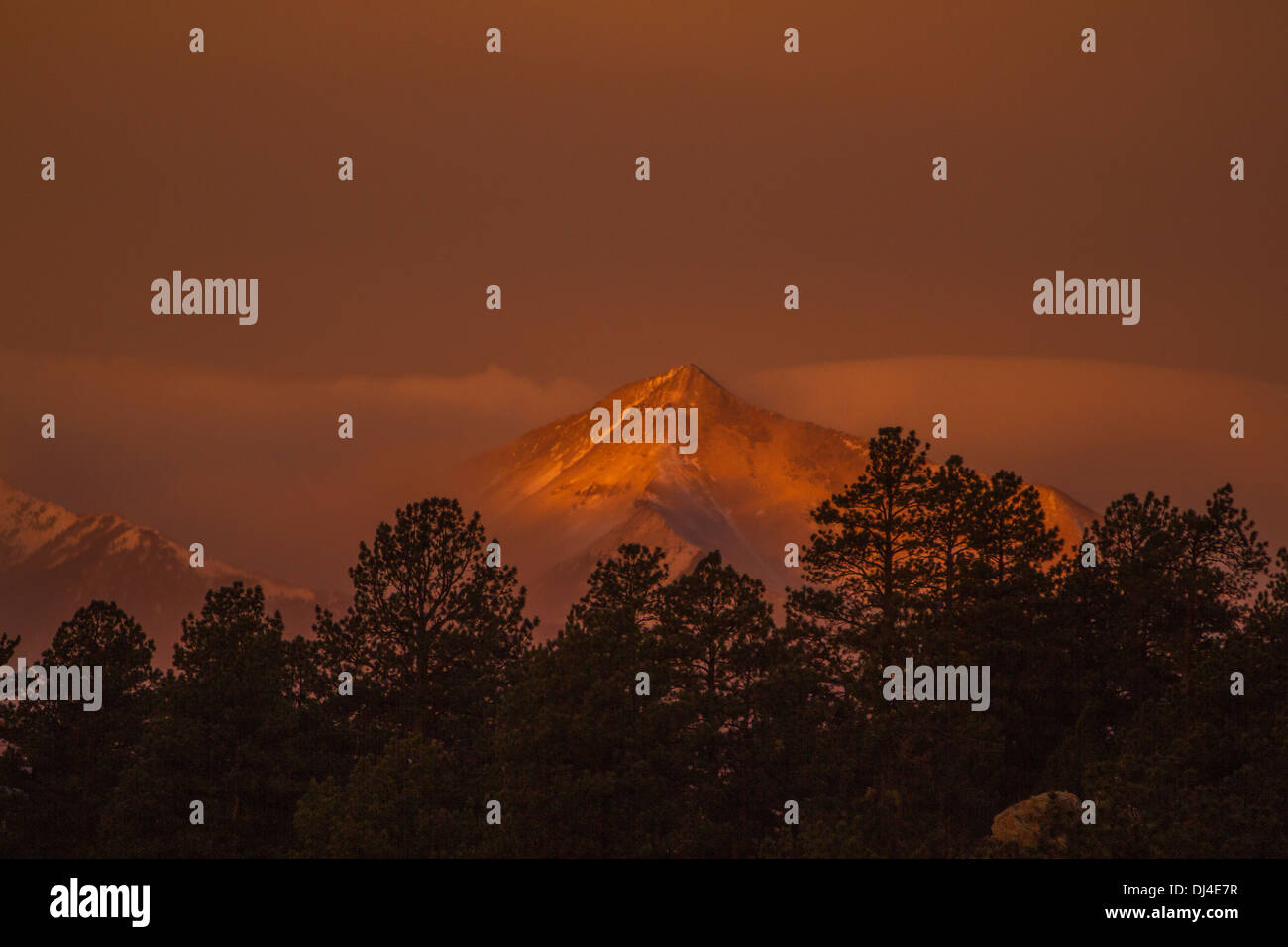 Sunset over snowy mountain peak Stock Photo - Alamy