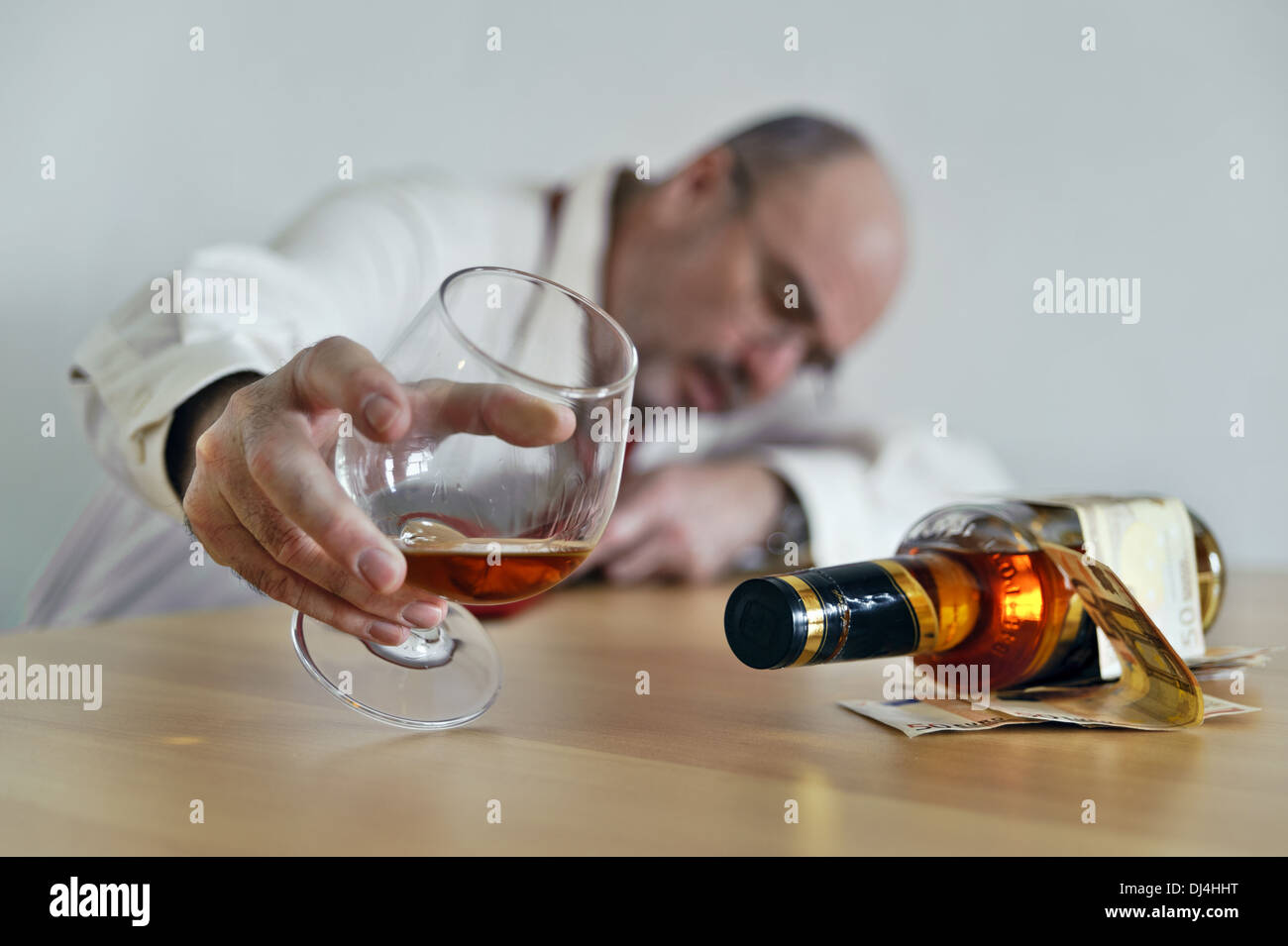 Alcoholic with a shot glass and bottle Stock Photo - Alamy
