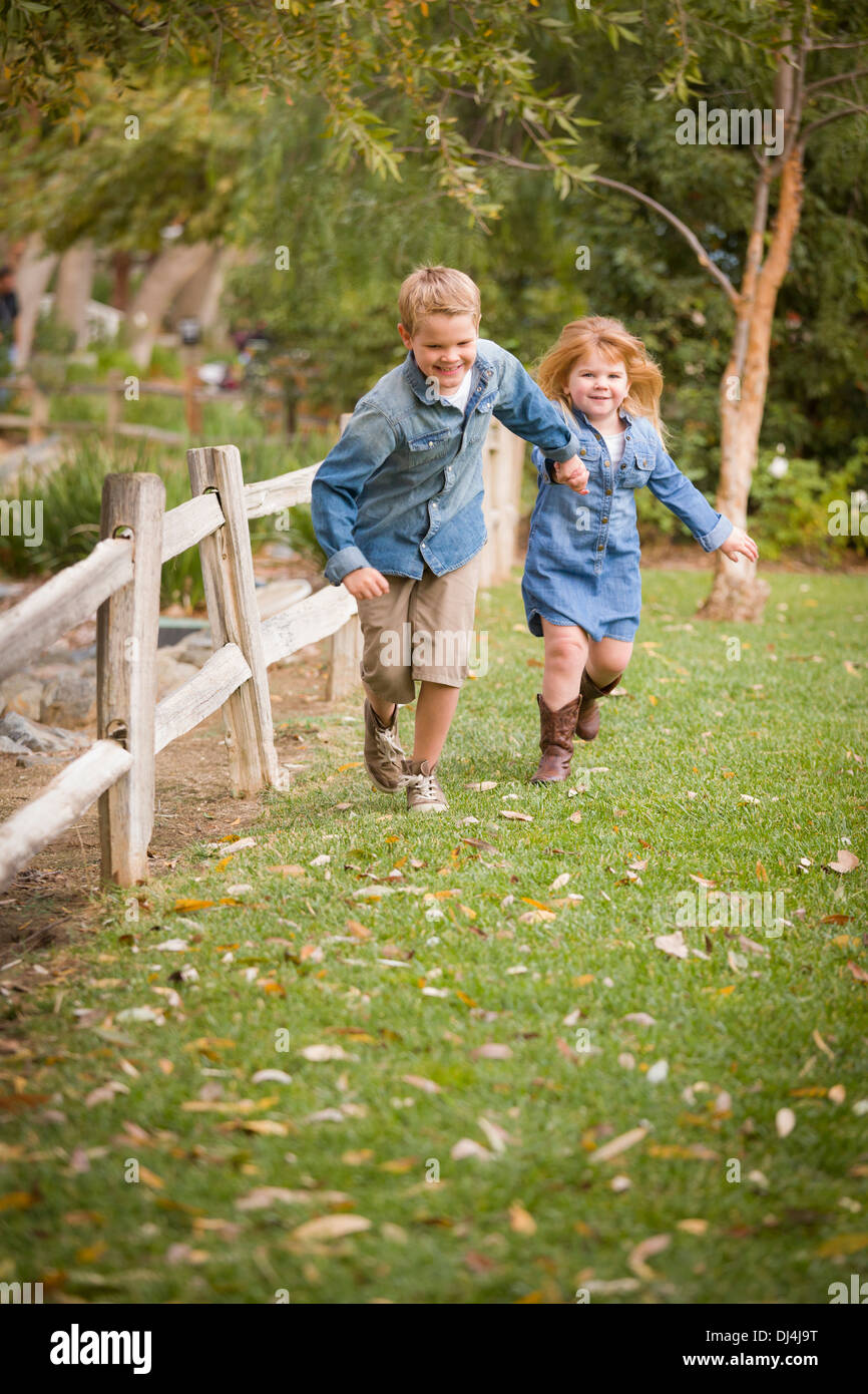 Happy Young Brother and Sister Running Together Outside Stock Photo - Alamy