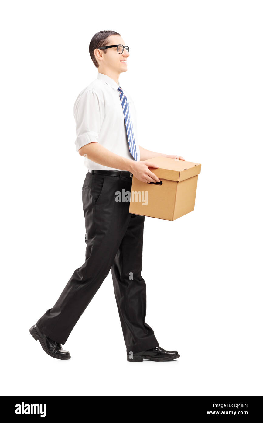 Full length portrait of a smiling young man walking with a paper box in ...