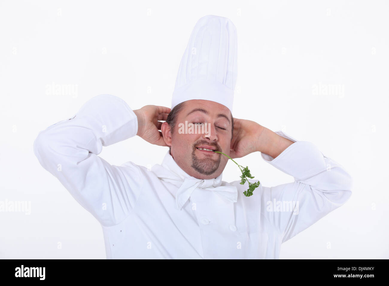 Chef chewing on parsley Stock Photo - Alamy