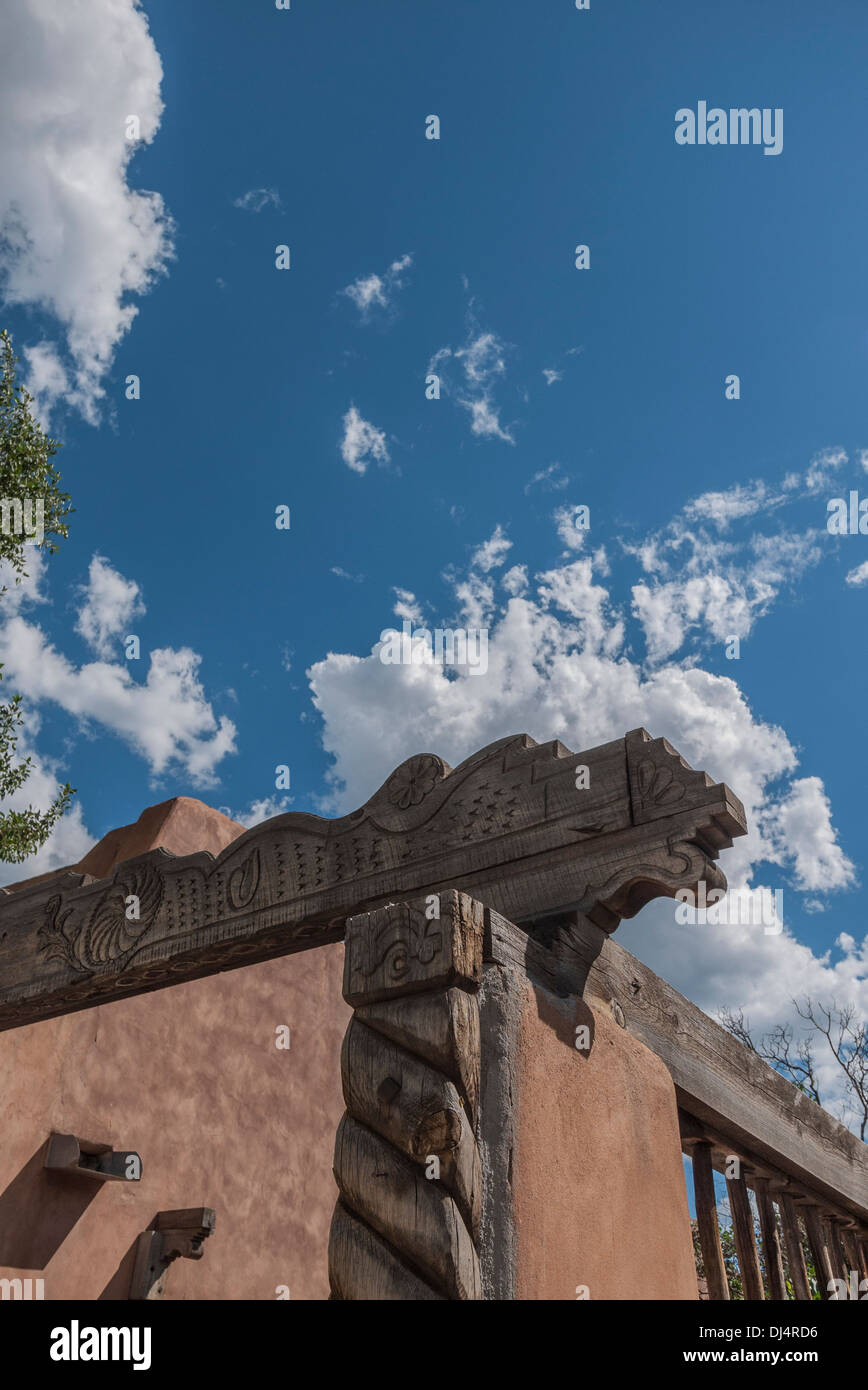 An adobe wall that is decorated with fancy wood carvings in the ...