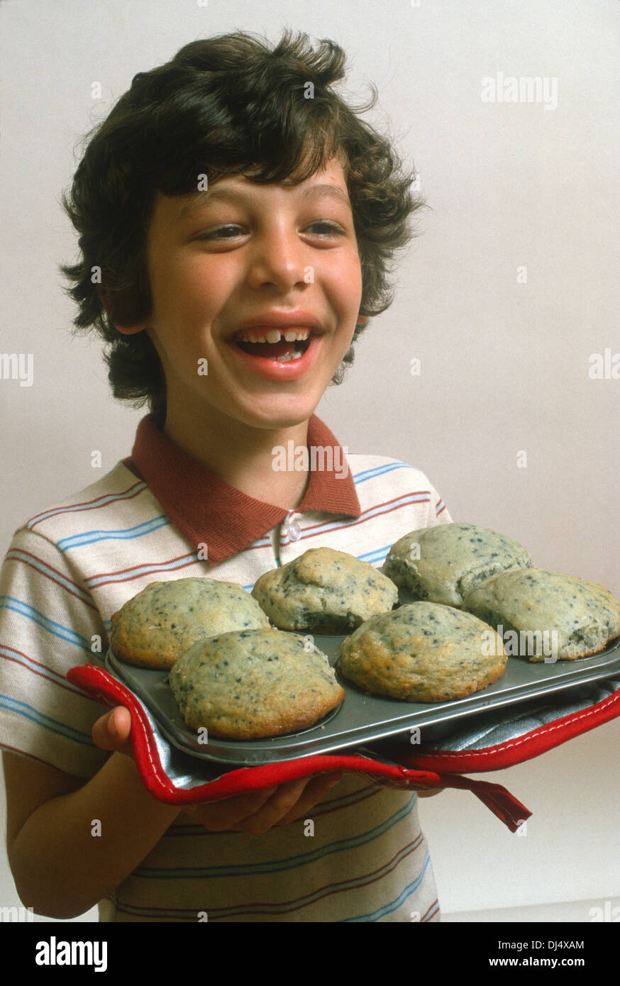 Boy with a pan of blueberry muffins Stock Photo - Alamy