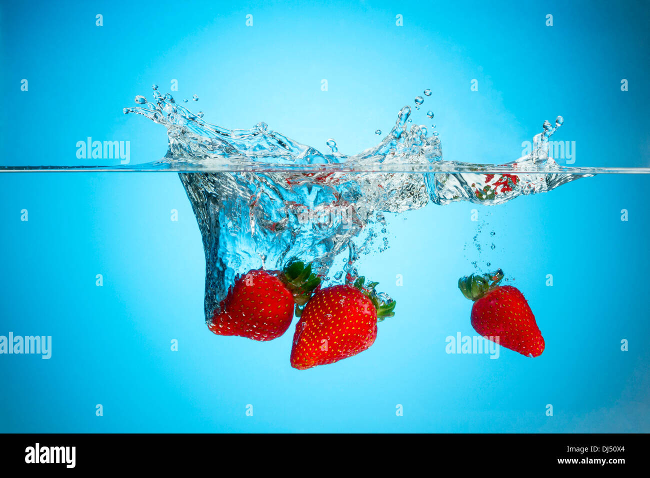 Fresh strawberries splashing in water Stock Photo - Alamy