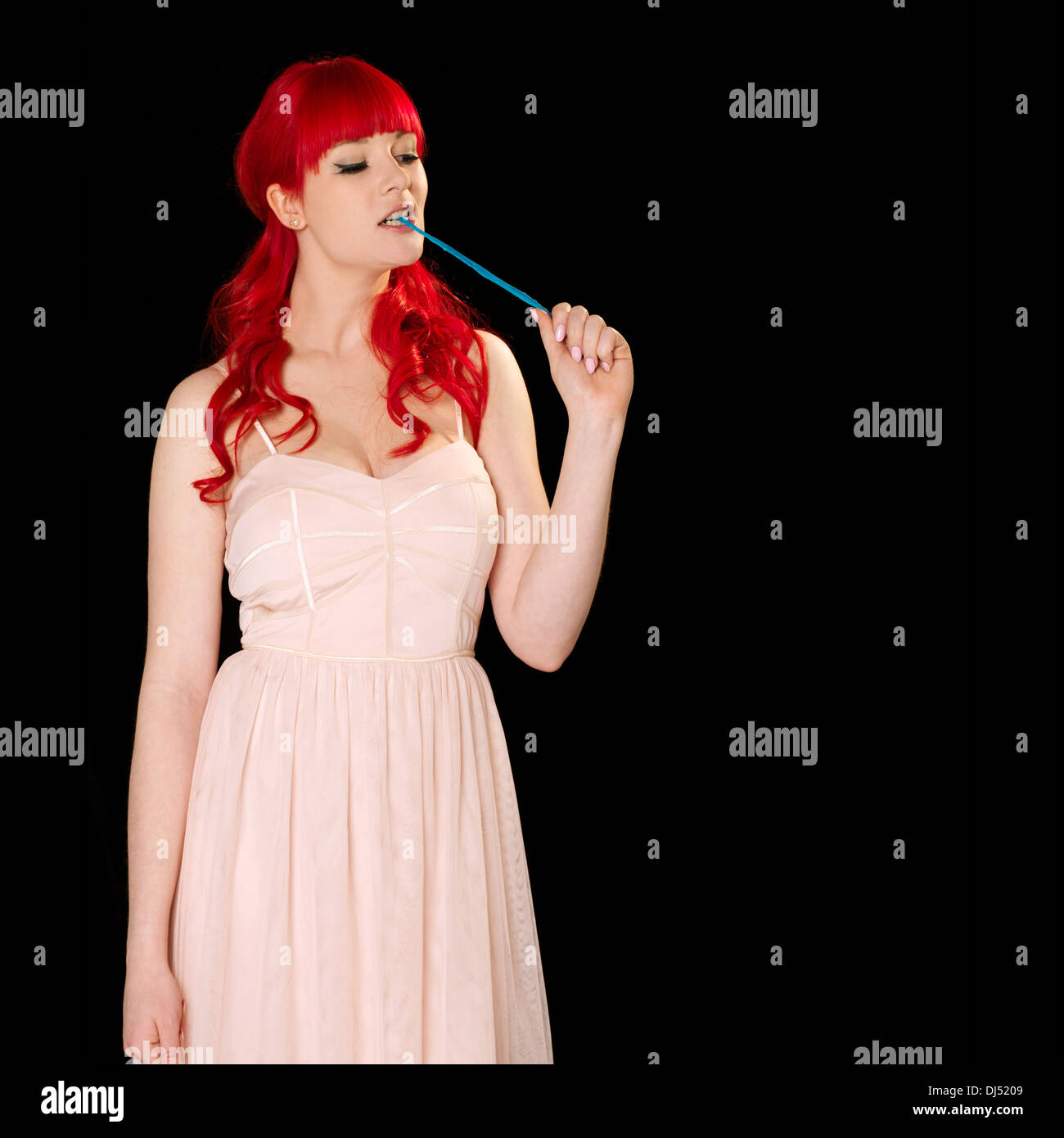 red haired woman eating blue sweet Stock Photo - Alamy