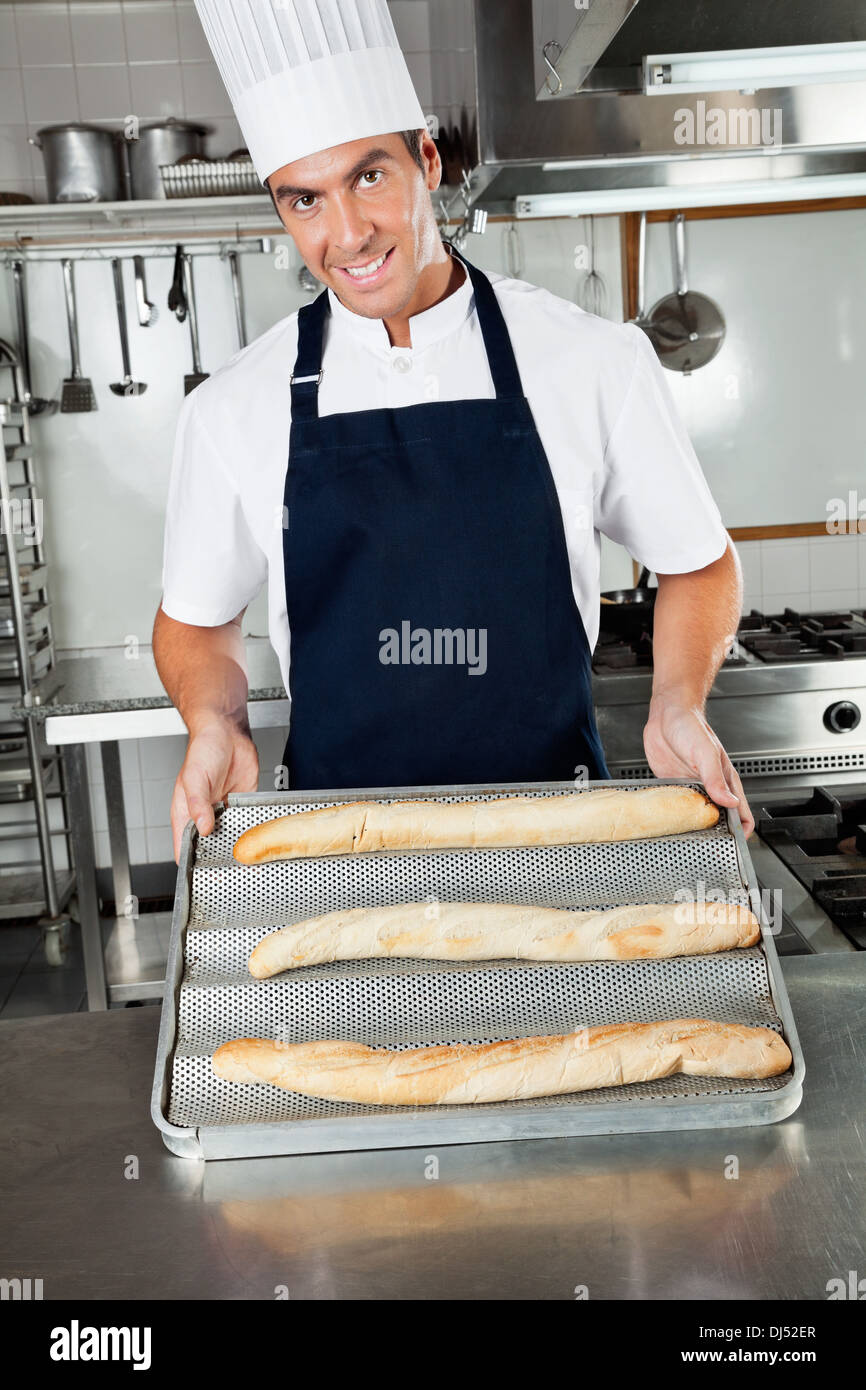 Male Chef Presenting Baked Loafs In Kitchen Stock Photo - Alamy