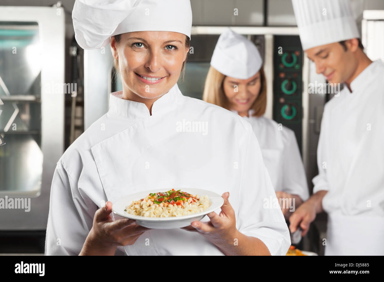 Happy Female Chef Presenting Dish Stock Photo - Alamy