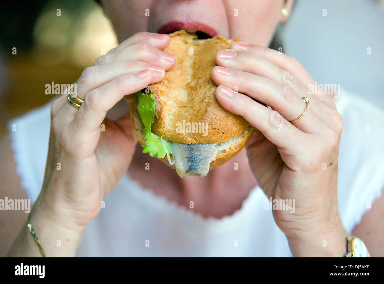 Woman eating a fish sandwich Stock Photo - Alamy