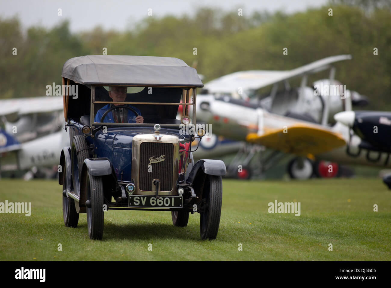 Vintage car drives along a line of aircraft at a Shuttleworth ...