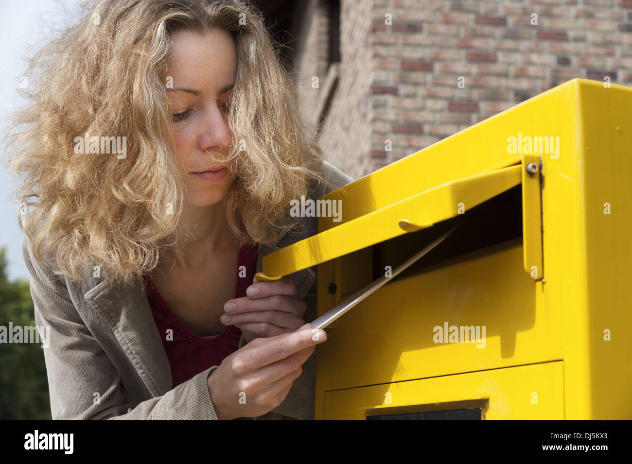 young woman with a letter at a mailbox Stock Photo - Alamy
