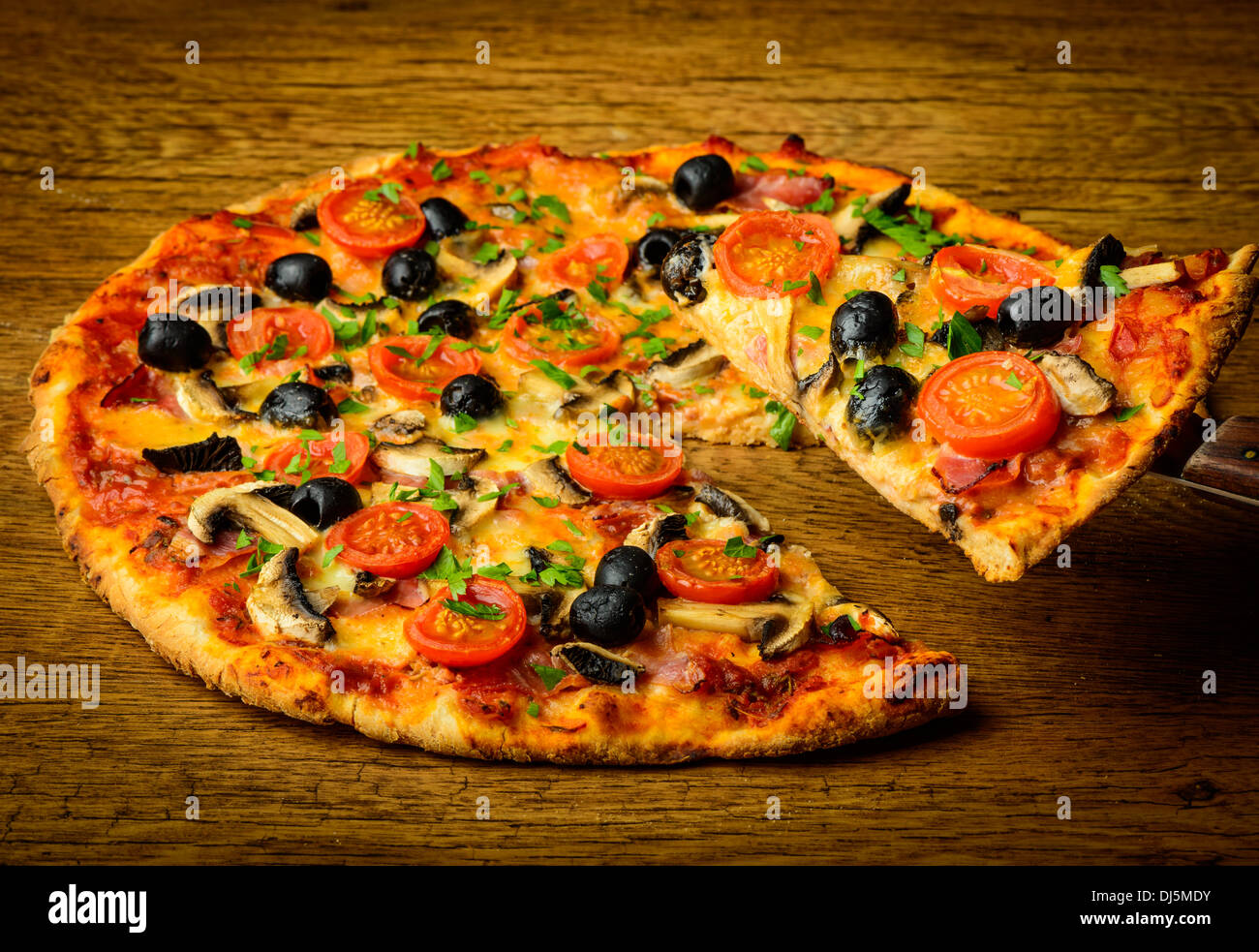 traditional italian homemade pizza with tomatoes, olives and mushrooms ...
