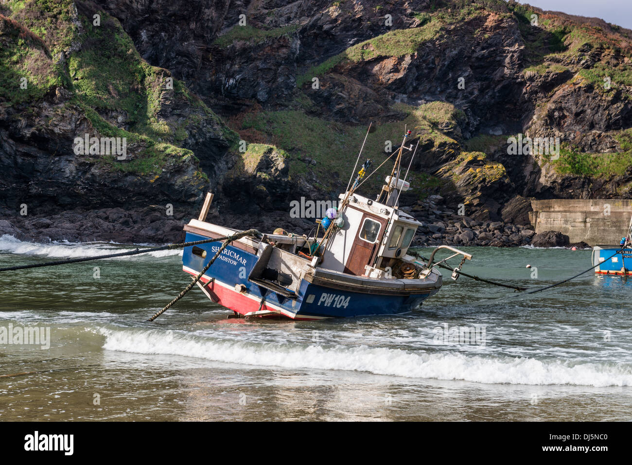 Fishing boat in Port Isaac Cornwall with the tide coming in Stock Photo ...