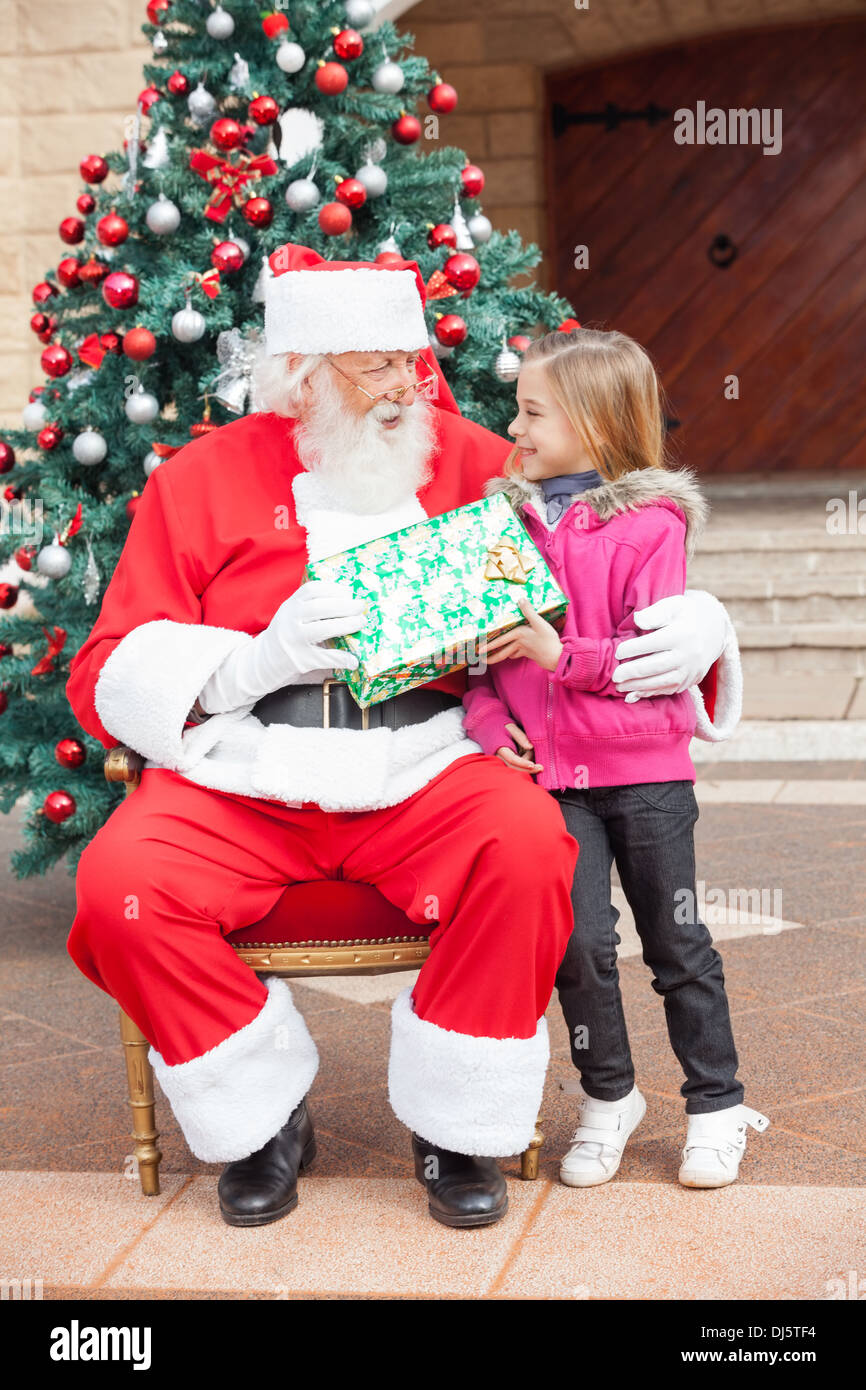 Santa Claus Giving Gift To Girl Stock Photo - Alamy