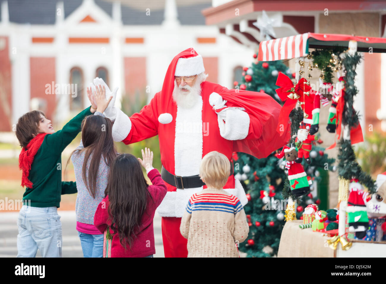 Children Giving High Five To Santa Claus Stock Photo - Alamy