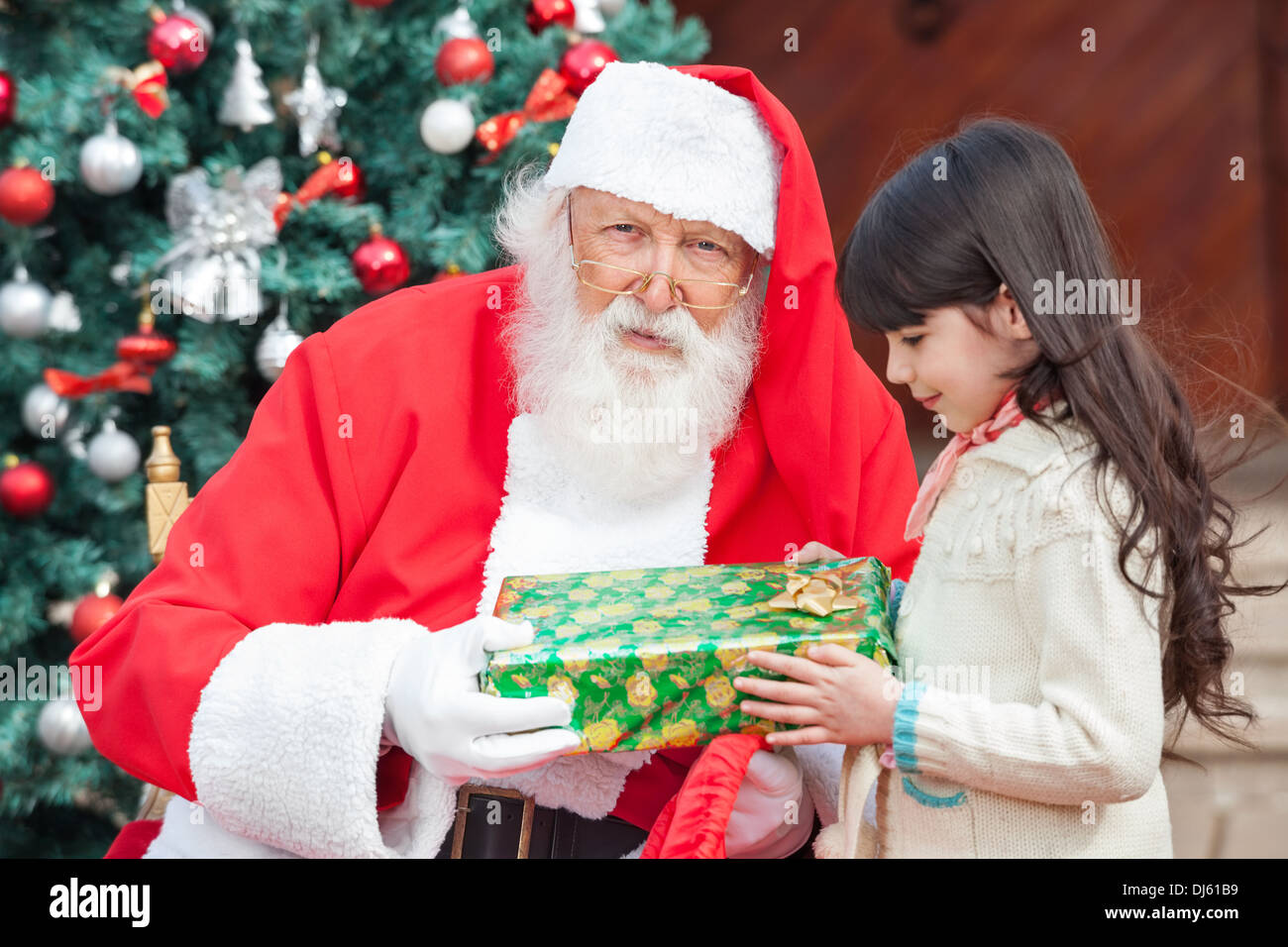 Santa Claus Giving Present To Girl Stock Photo - Alamy