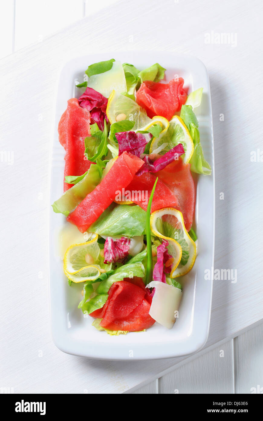 Green salad with thin slices of lemon and raw beef Stock Photo - Alamy