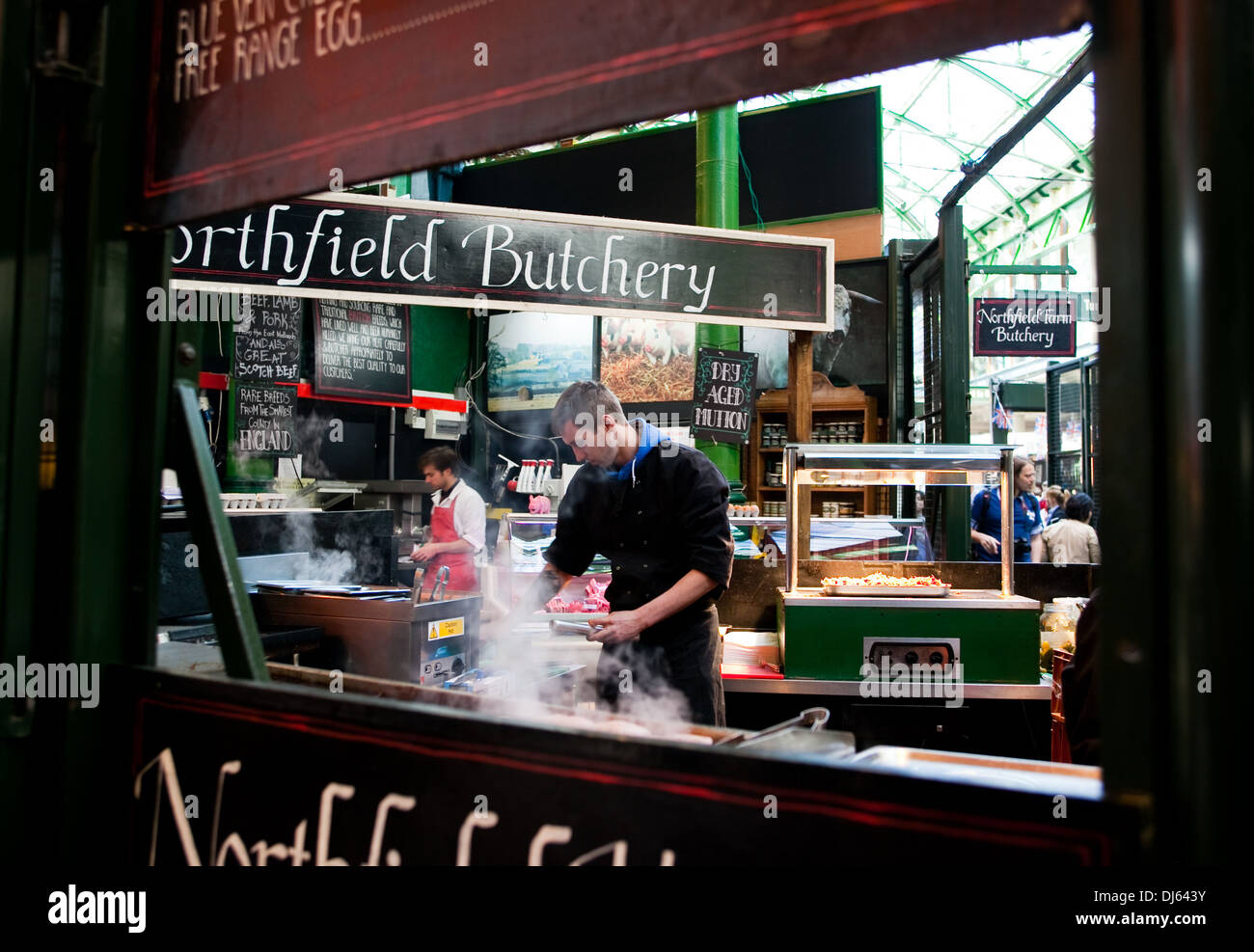 A seller prepares burgers at Borough Market - London's famous artisan ...