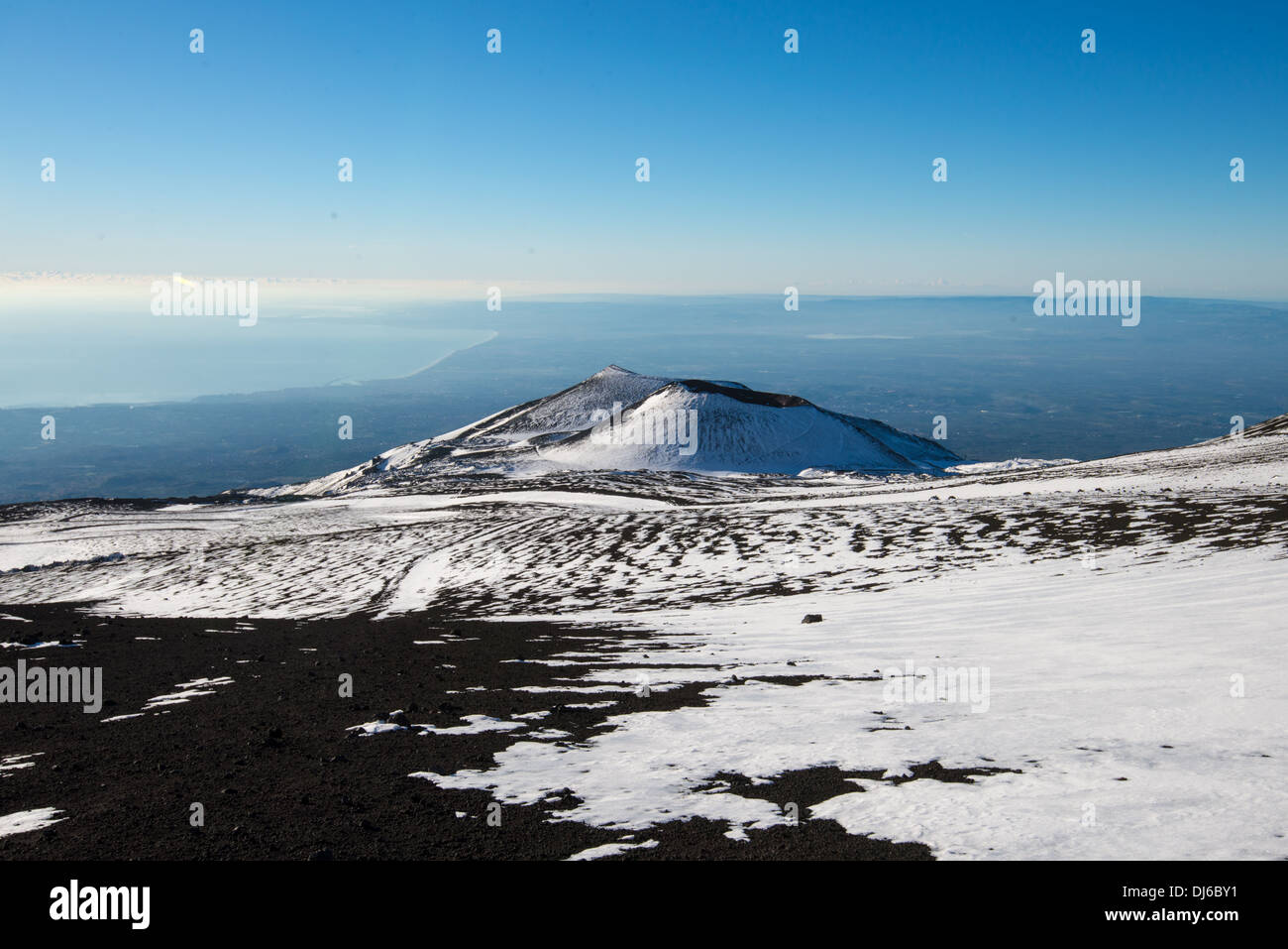 Early morning view from snow-covered Etna volcano towards Catania Bay ...