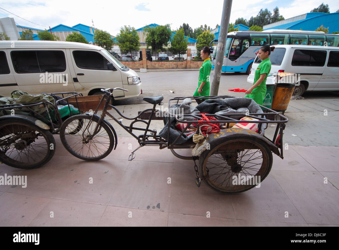Working class chinese lady walk pass a chained trishaw Stock Photo - Alamy