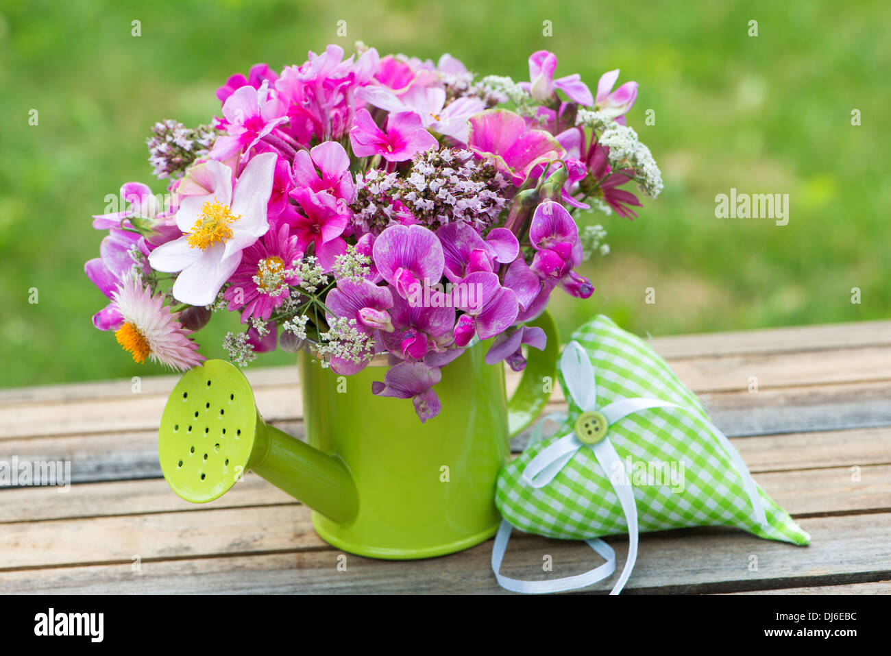Pink garden flowers in a small watering can Stock Photo - Alamy
