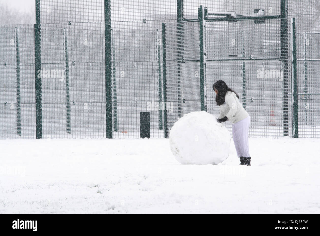 girl pushing a huge snowball Stock Photo - Alamy