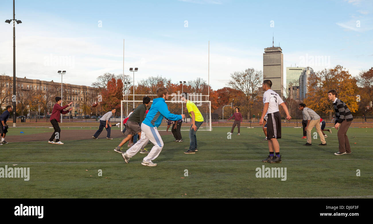 Male and female college students play football together in Boston Stock ...