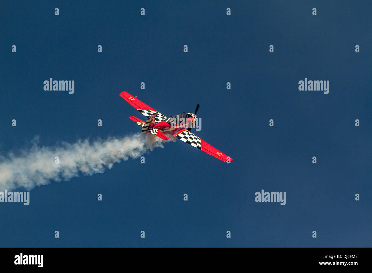 Airplane with Smoke flying on a perfect blue sky Stock Photo - Alamy