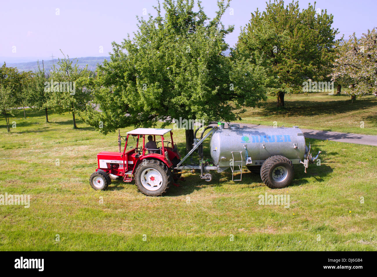 Tractor in green field in Switzerland Stock Photo - Alamy