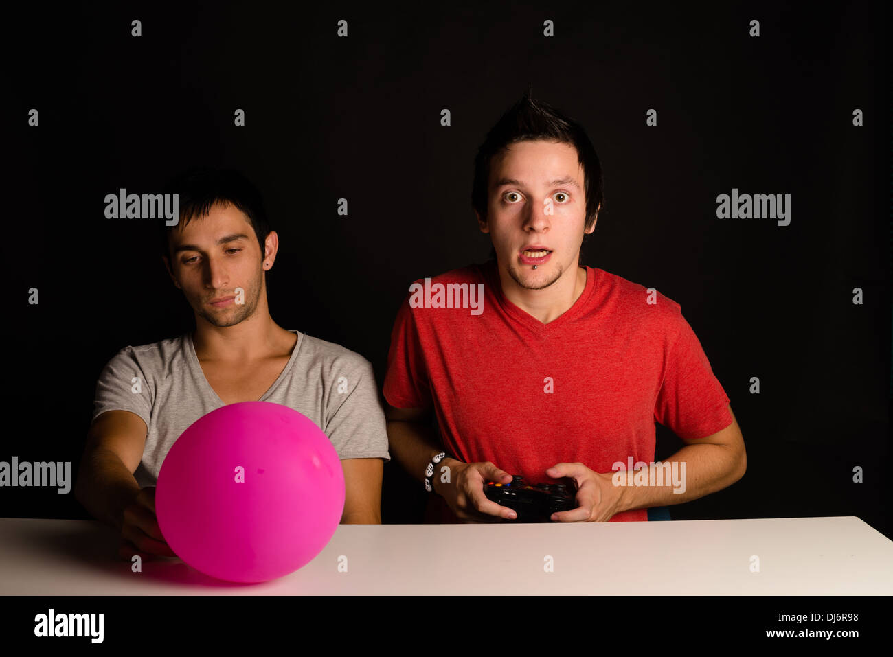 Two friends sitting together, one gaming the other bored, a concept ...