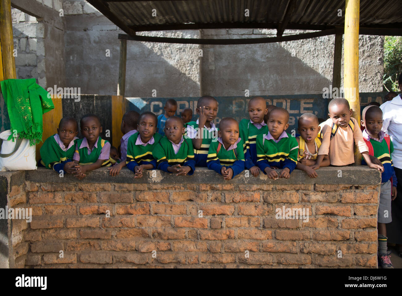 Local african school children at their school and a child makes a ...