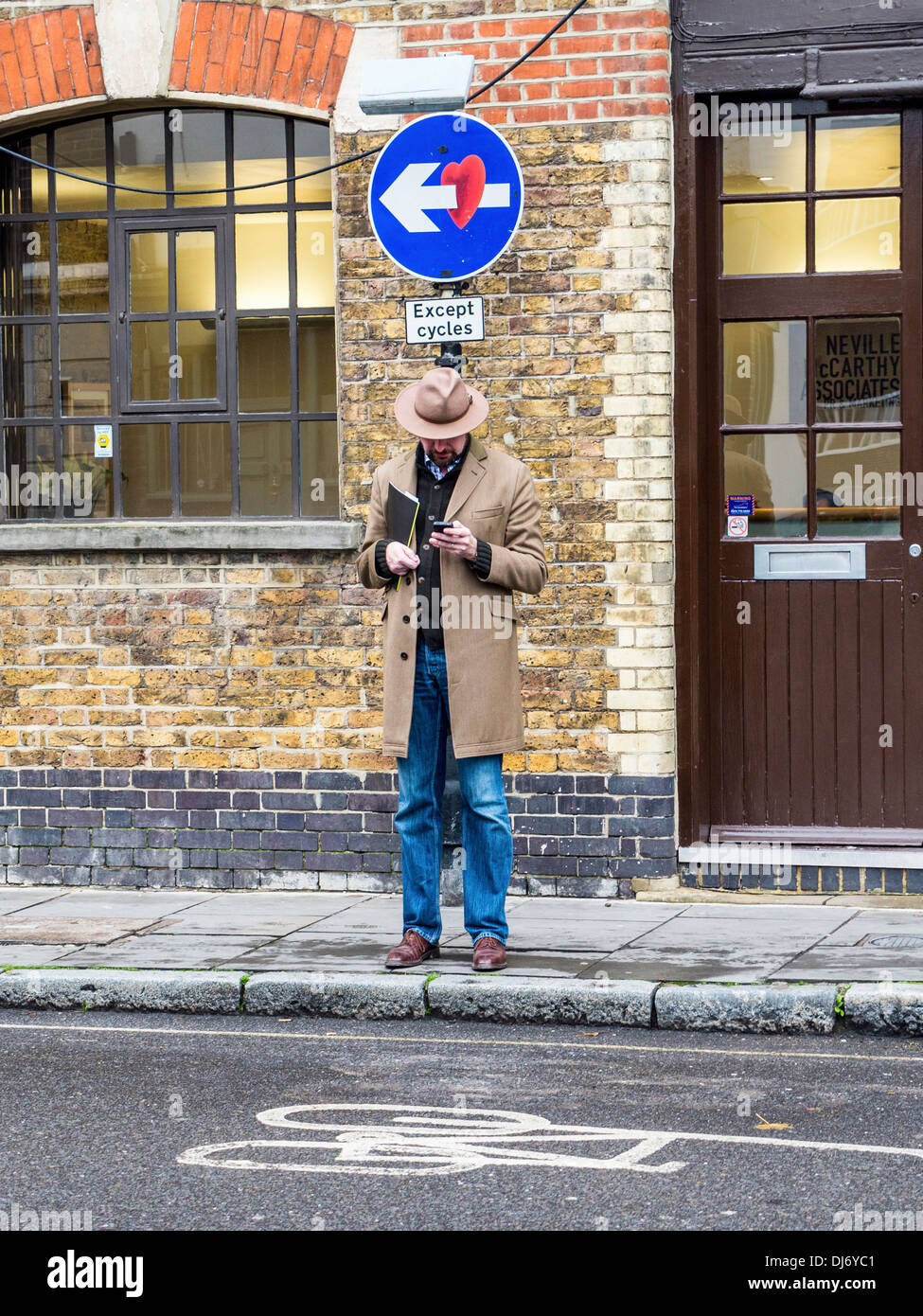 Well dressed man using mobile phone under quirky, funny traffic control ...