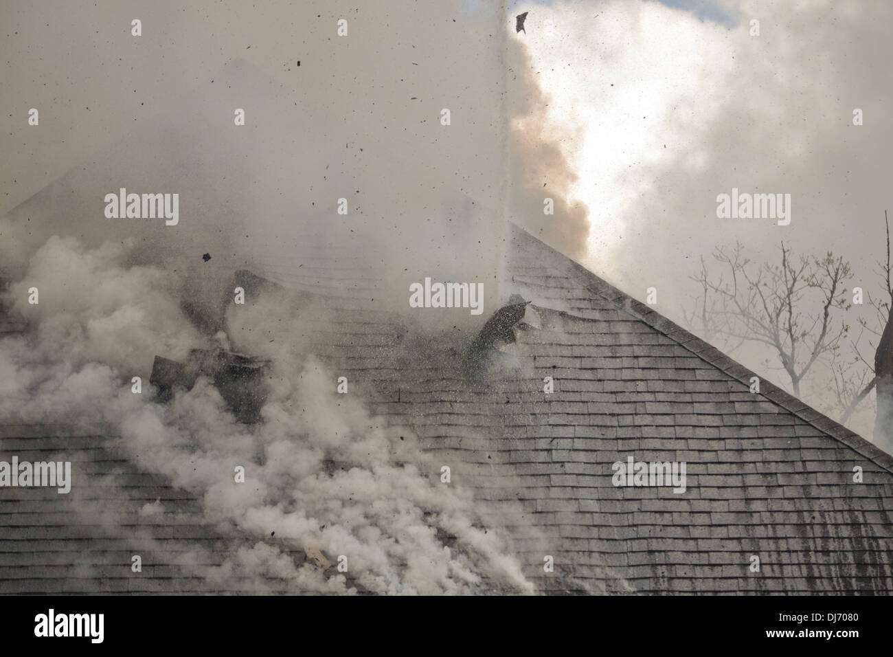 Water blasting through the roof of a training fire at an old house Stock Photo - Alamy