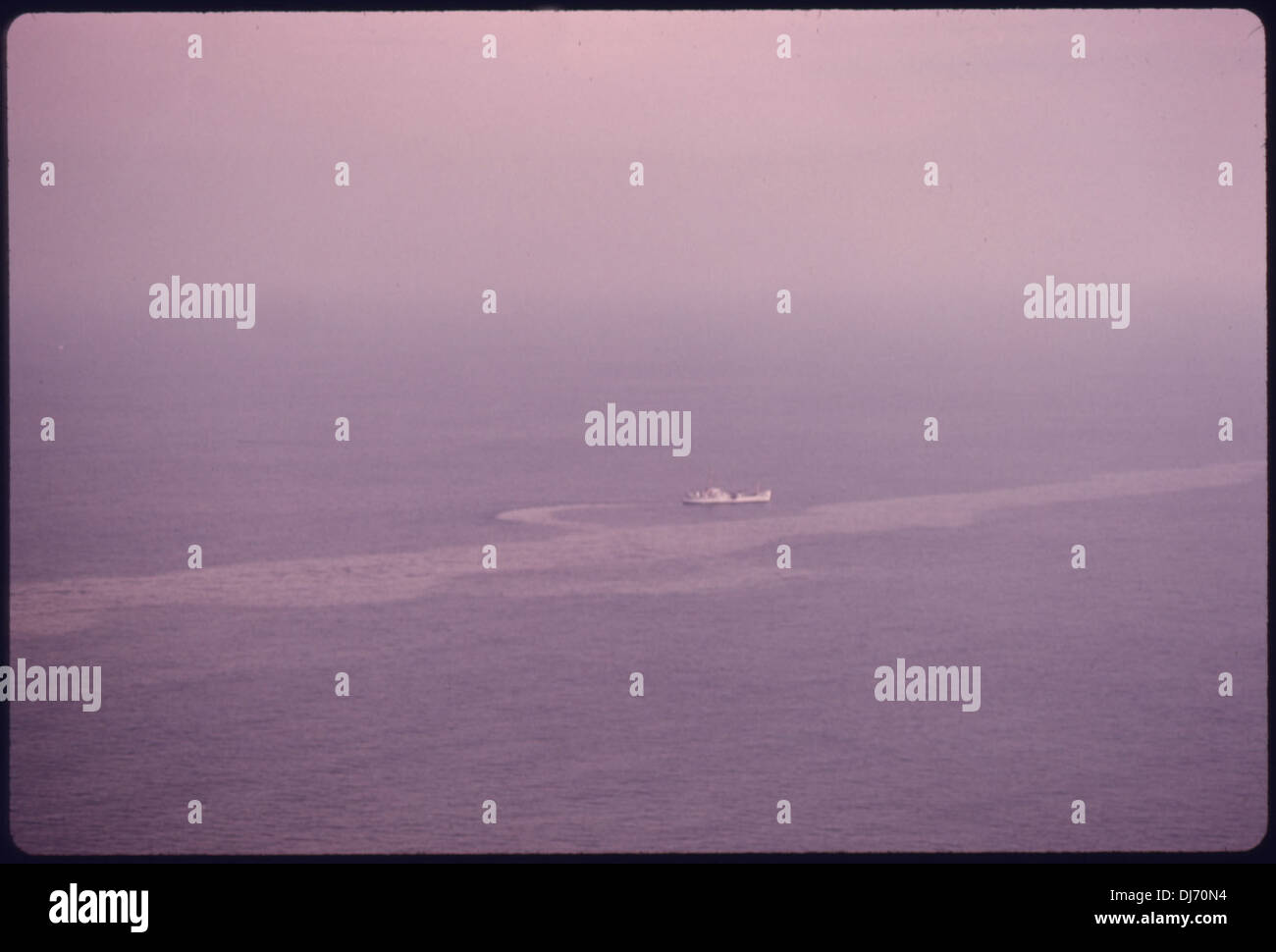 IN THE DISTANCE, A NEW YORK CITY SLUDGE CARRIER DUMPS ITS CARGO INTO ...