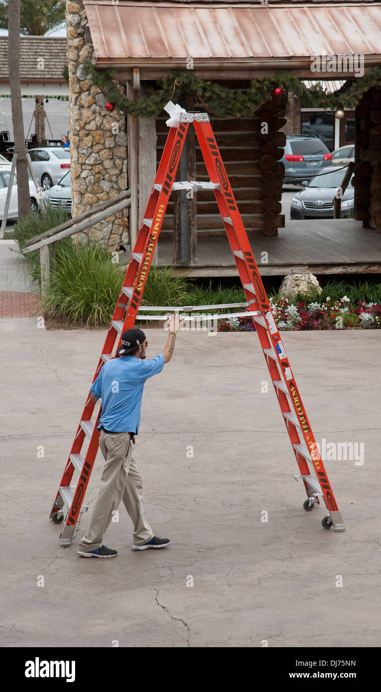 Man moving a large ladder in the new village of Brownwood Florida USA ...