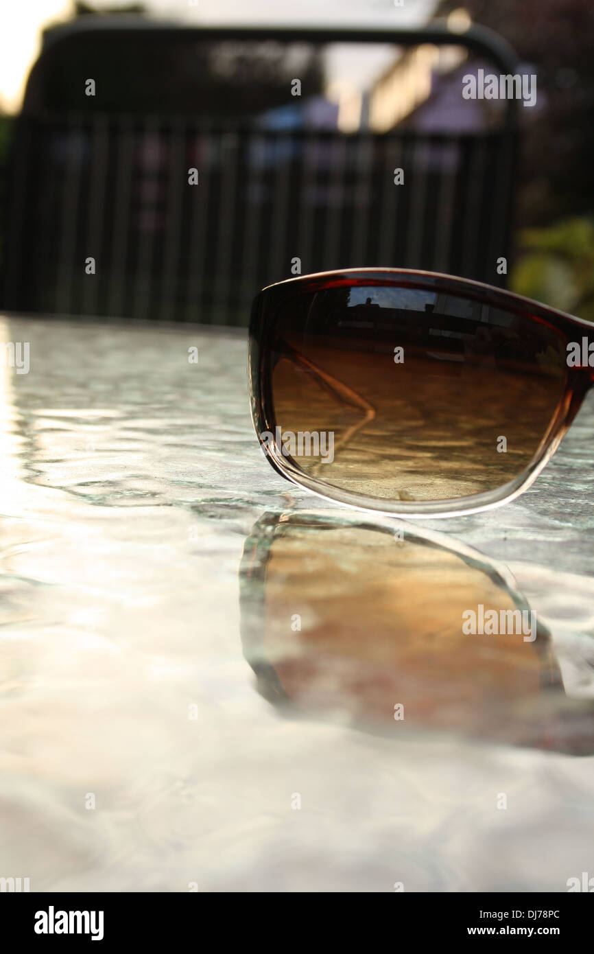 One half of a pair of brown sunglasses with reflection captured on a ...