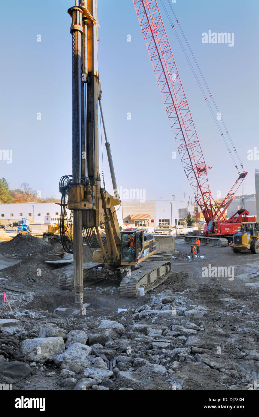 Heavy construction showing dirt drilling machine and crane Stock Photo ...