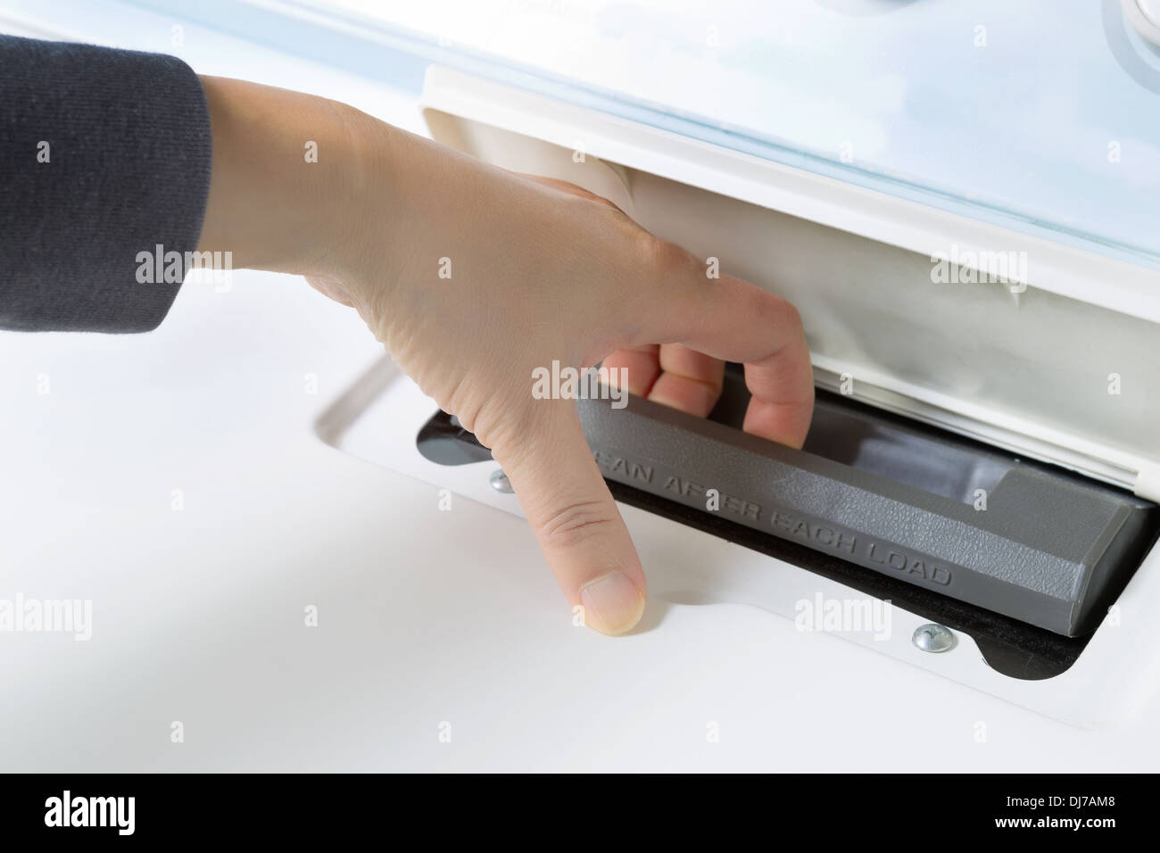 Horizontal photo of female hand pulling out filter on dyer machine ...