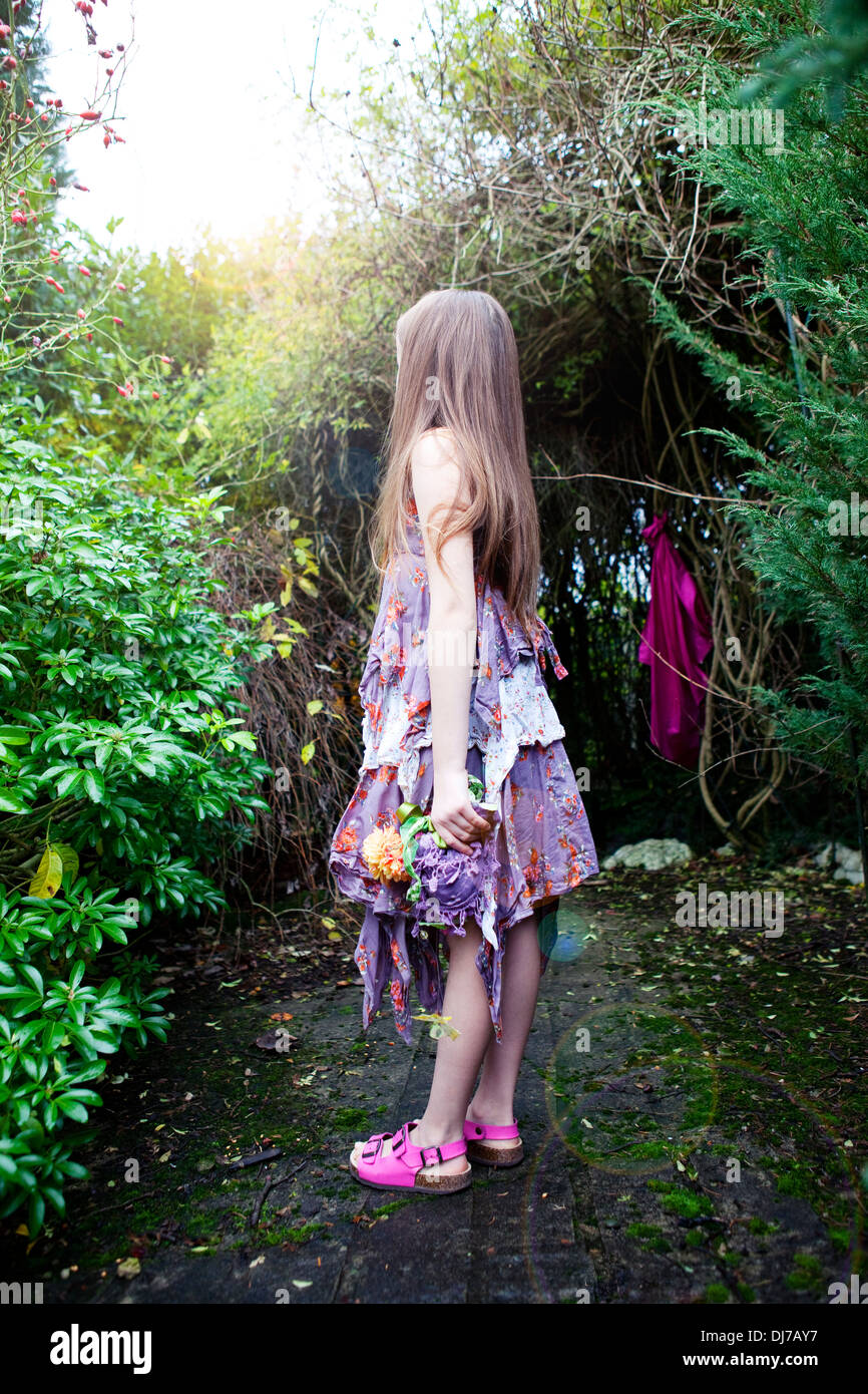 Girl outdoors wearing ragged dress and looking towards the light on a ...
