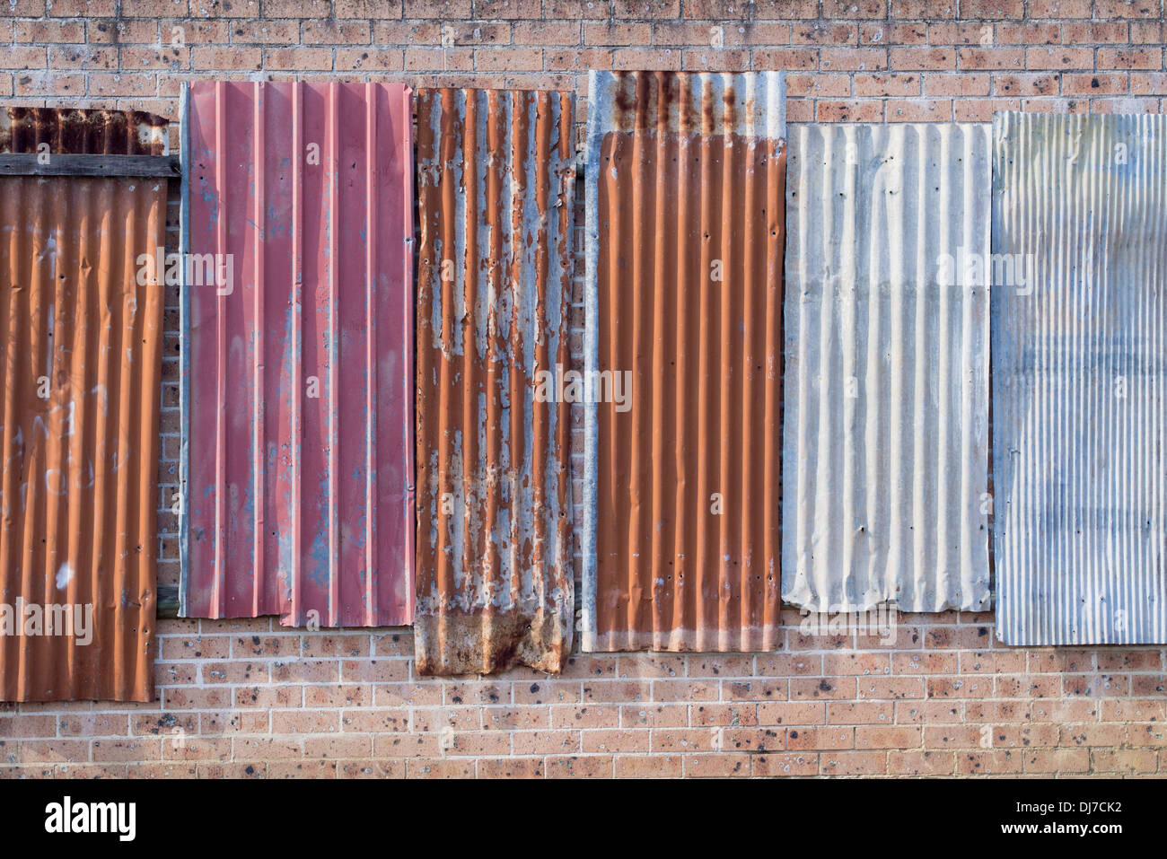 Weathered corrugated iron panels attached to a brick wall Stock Photo ...