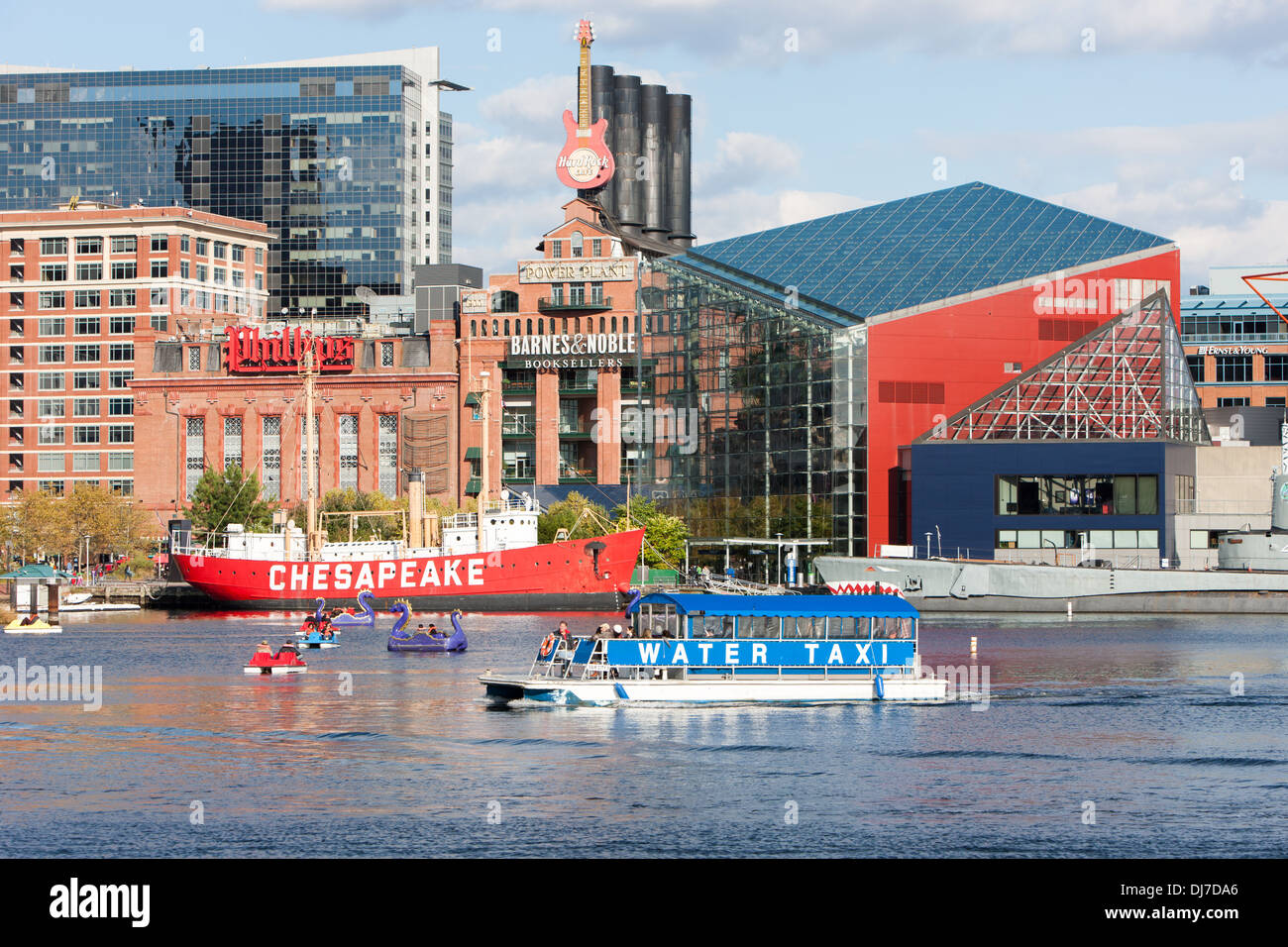 Tourists enjoy paddle boats as a Water Taxi approaches the Harborplace ...
